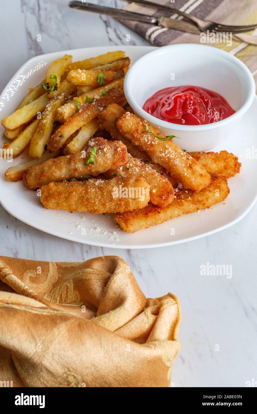 American fish sticks and french fries with ketchup on marble kitchen ...