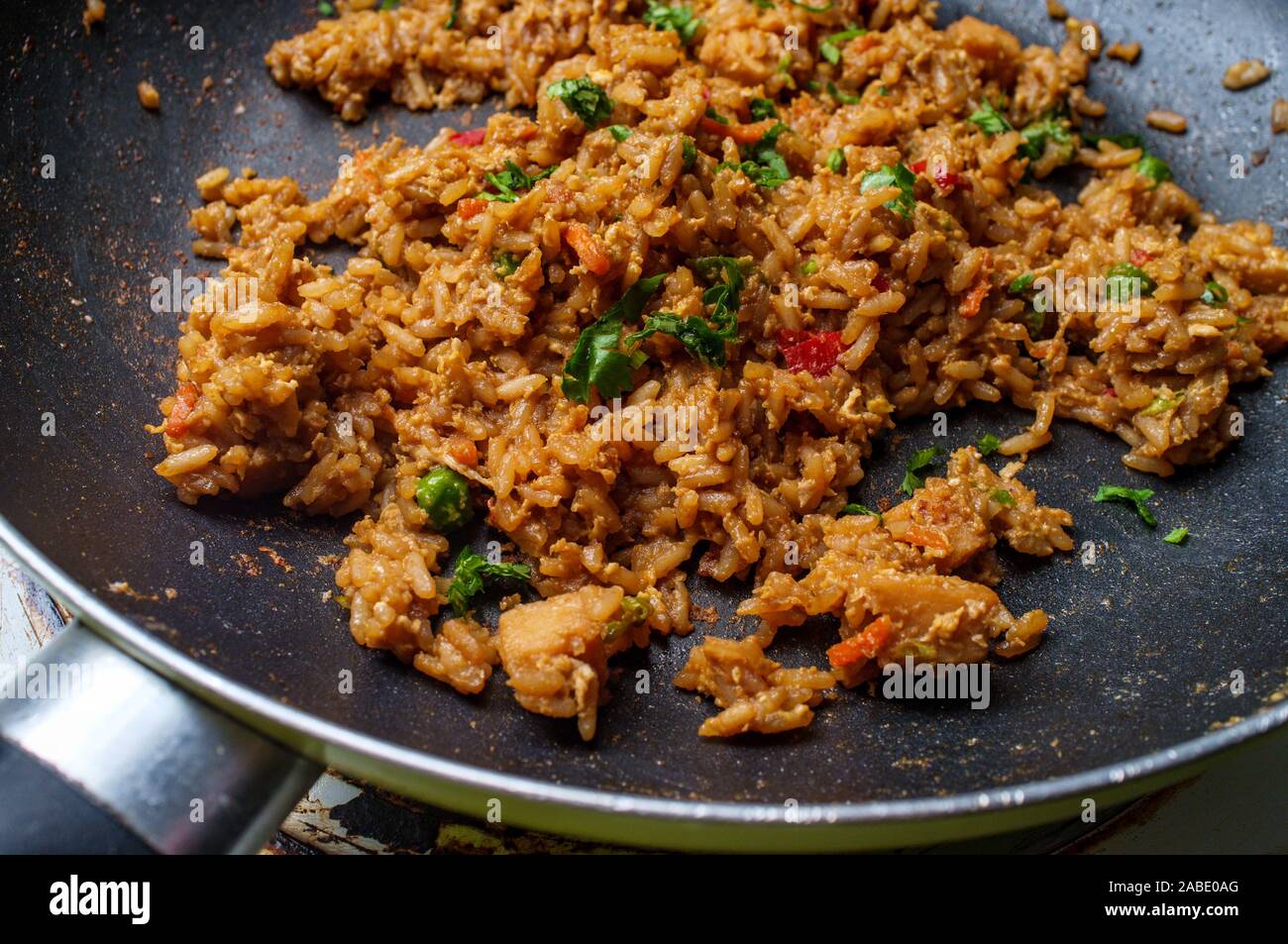 Cooking Chinese chicken fried rice in stovetop wok Stock Photo - Alamy