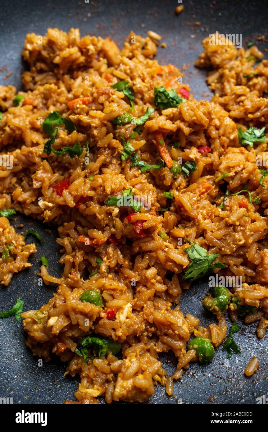 Cooking Chinese chicken fried rice in stovetop wok Stock Photo - Alamy