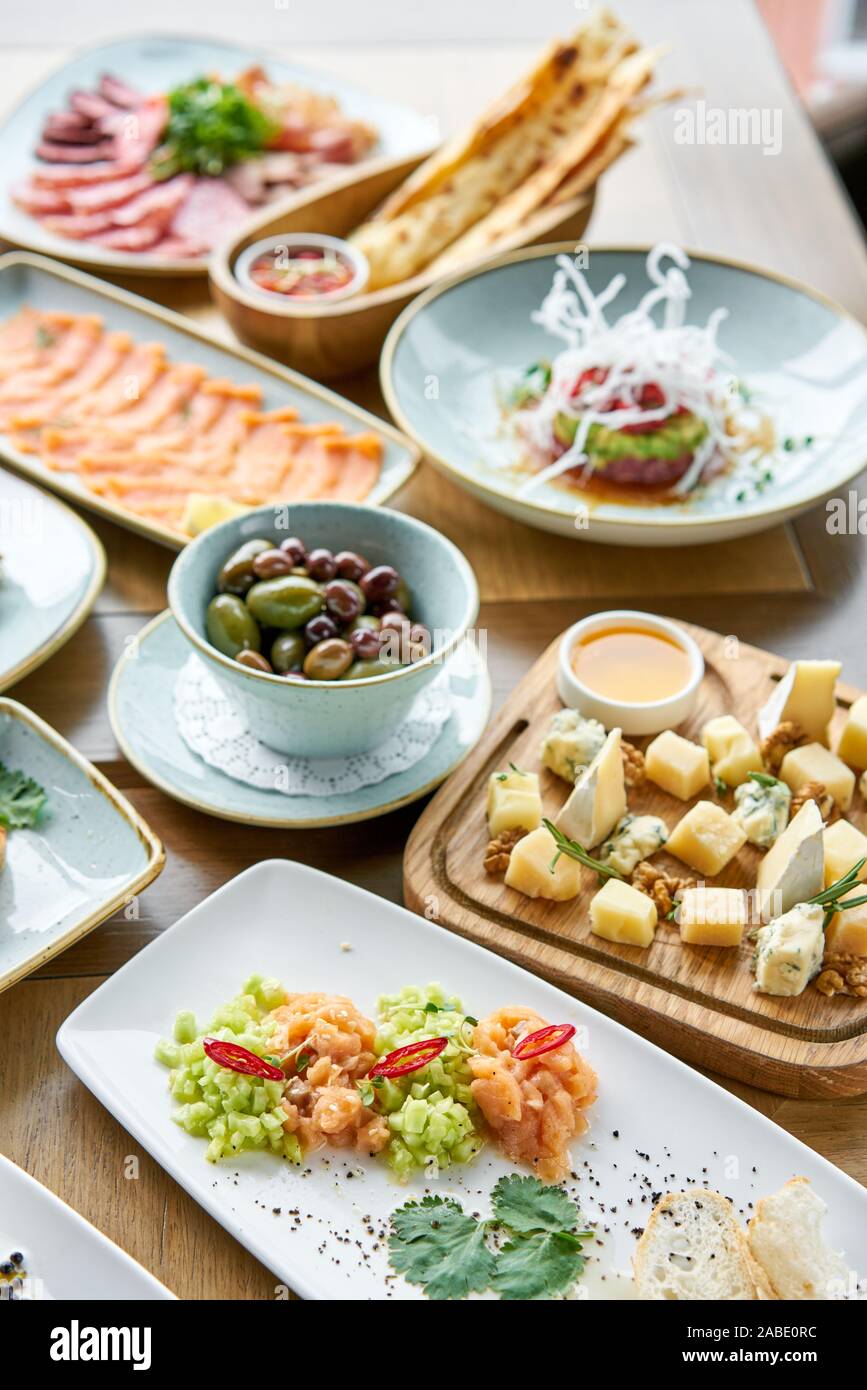 Cheese plate. Focus on delicious cheese mix with walnuts, honey on ...