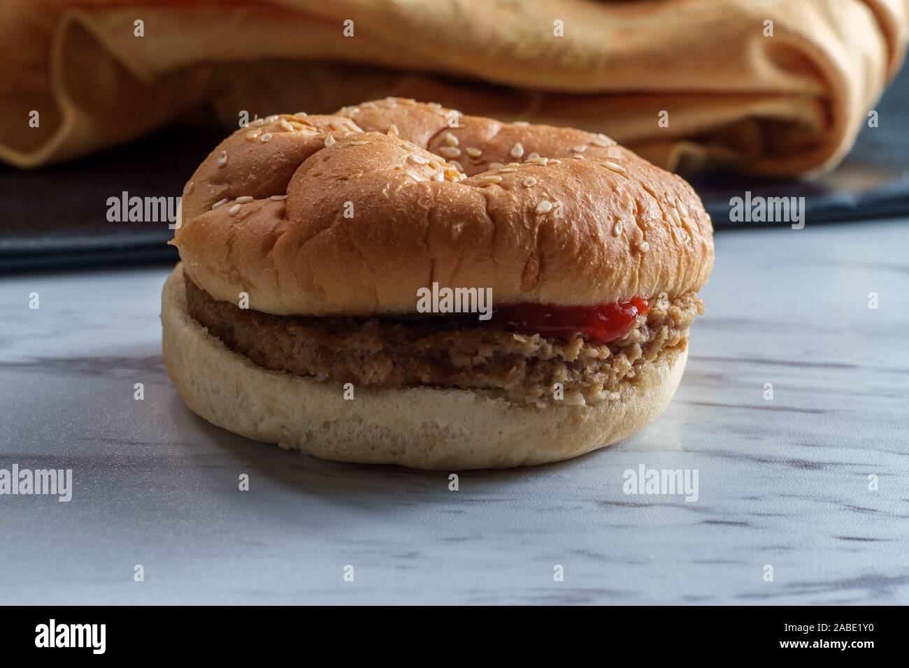 Plain boring microwaved hamburger on sesame seed bun with ketchup Stock ...