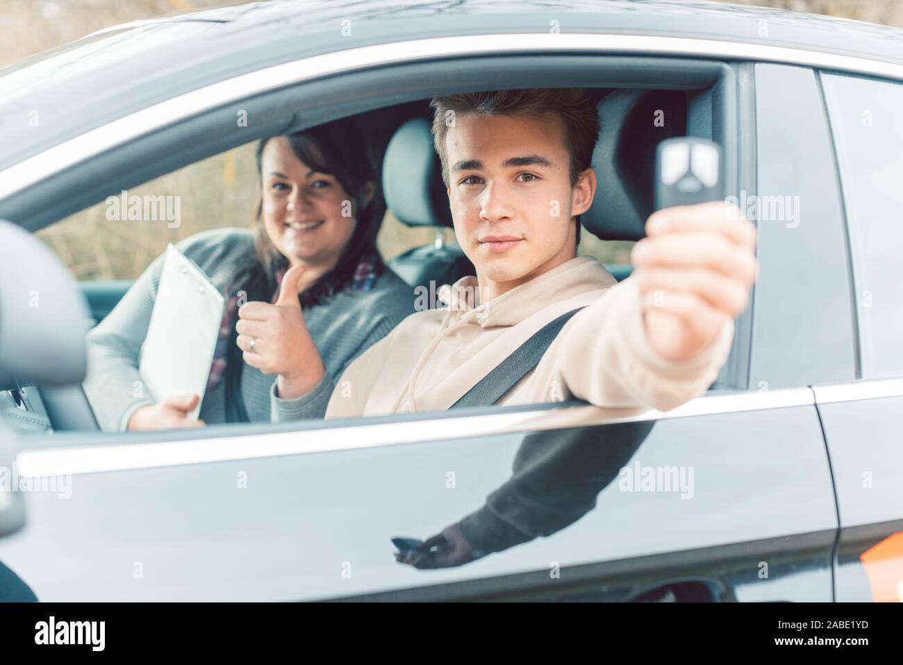Happy student of driving school showing car keys Stock Photo - Alamy