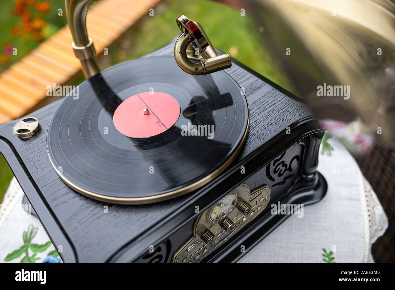 Vintage retro gramophone with vinyl record in the summer garden playing ...