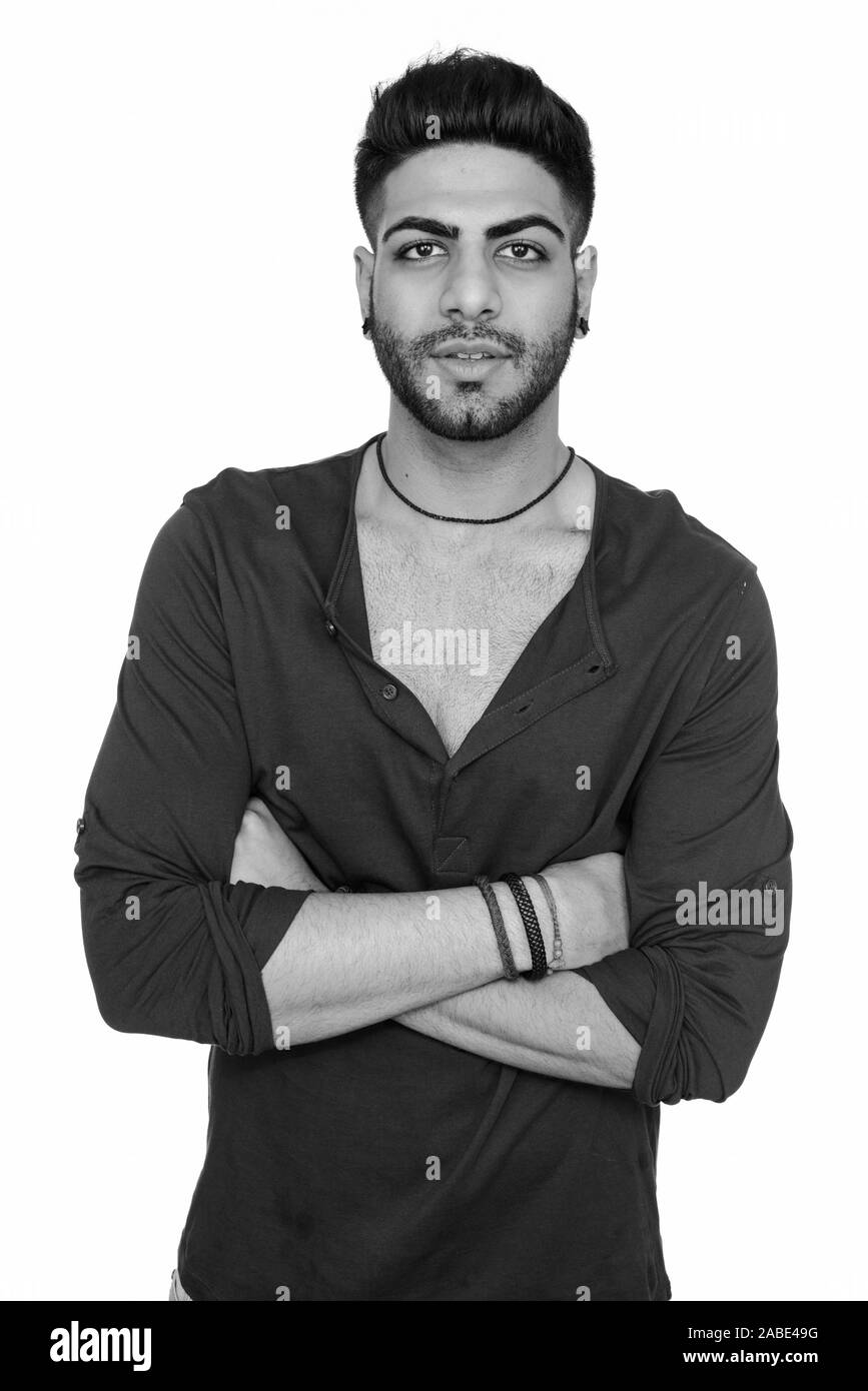 Studio shot of young handsome Indian man isolated against white ...