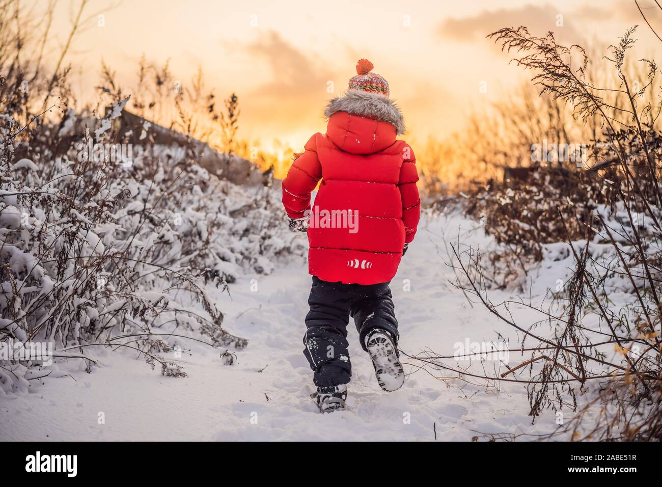 Cute boy in red winter clothes runs fun in the snow. Winter Fun Outdoor ...