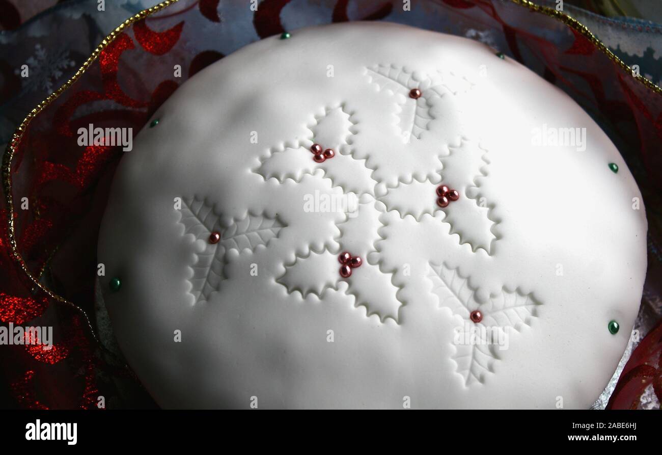 White icing Christmas cake decorated with holy , sparkling decorations ...