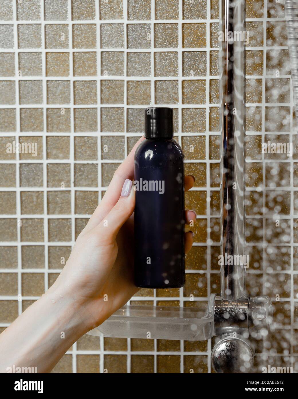 woman hand holding shower gel in navy bottle in the bathroom Stock ...