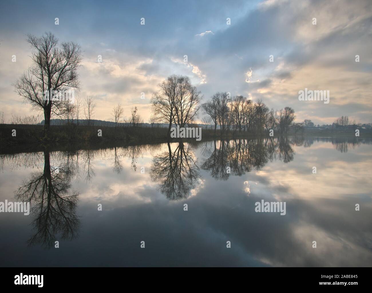 Calm autumn morning landscape with fog and warm sky over the pond ...