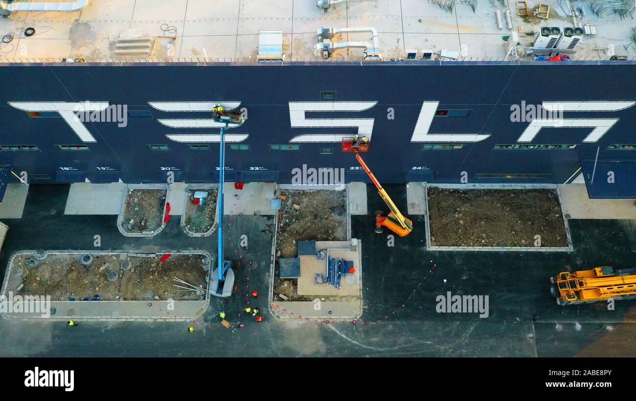 Construction workers put up the "Tesla" logo on the outside wall of ...