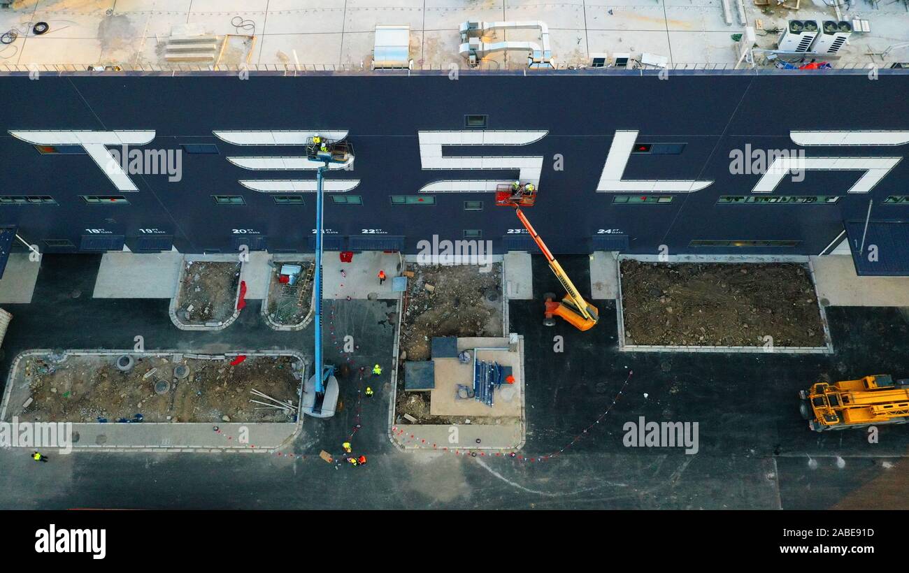 Construction workers put up the "Tesla" logo on the outside wall of ...
