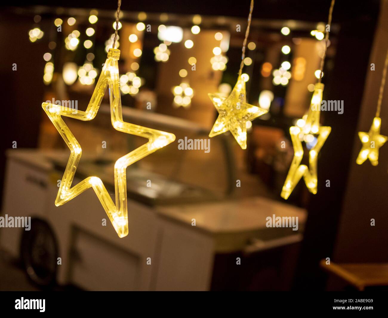 Diagonal row of electric lighted stars with warm yellow lights against ...