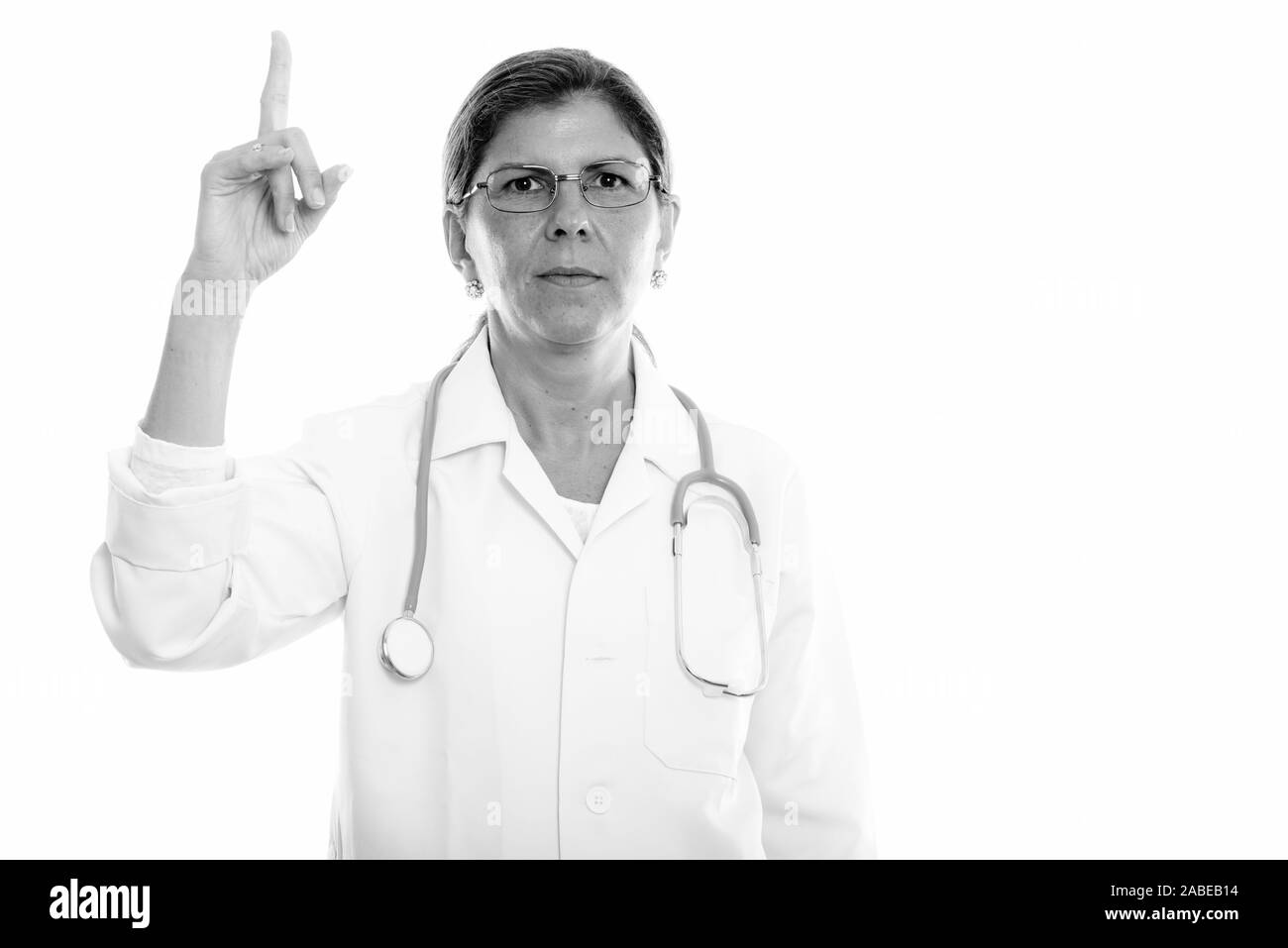Studio shot of mature beautiful woman doctor pointing finger up Stock ...