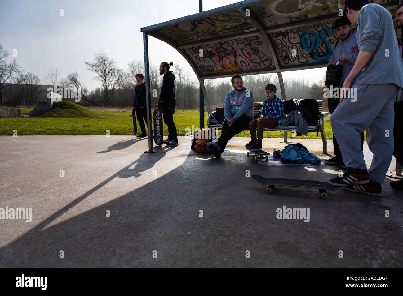 Friends hanging out together at the skatepark, chatting while having a ...