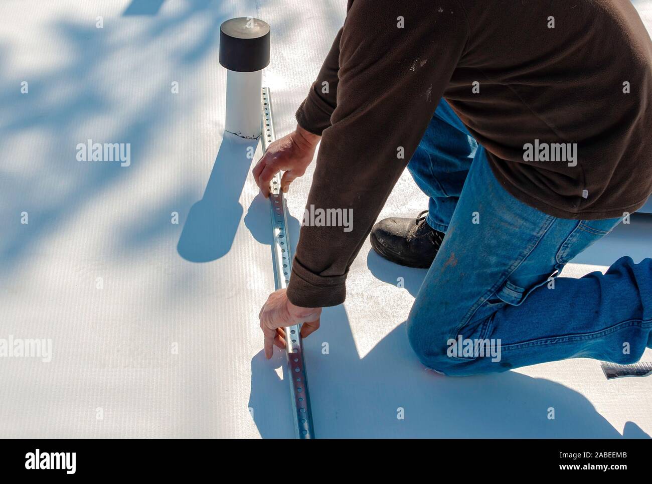 Worker with a heat gun is welding PVC sheets for waterproofing a ...