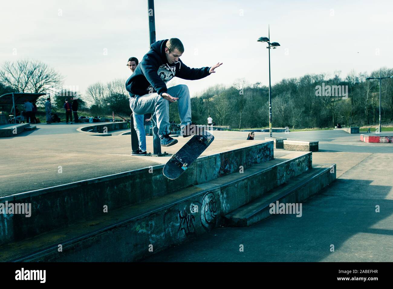 A group of professional skaters, skateboarders practicing ollieing off ...