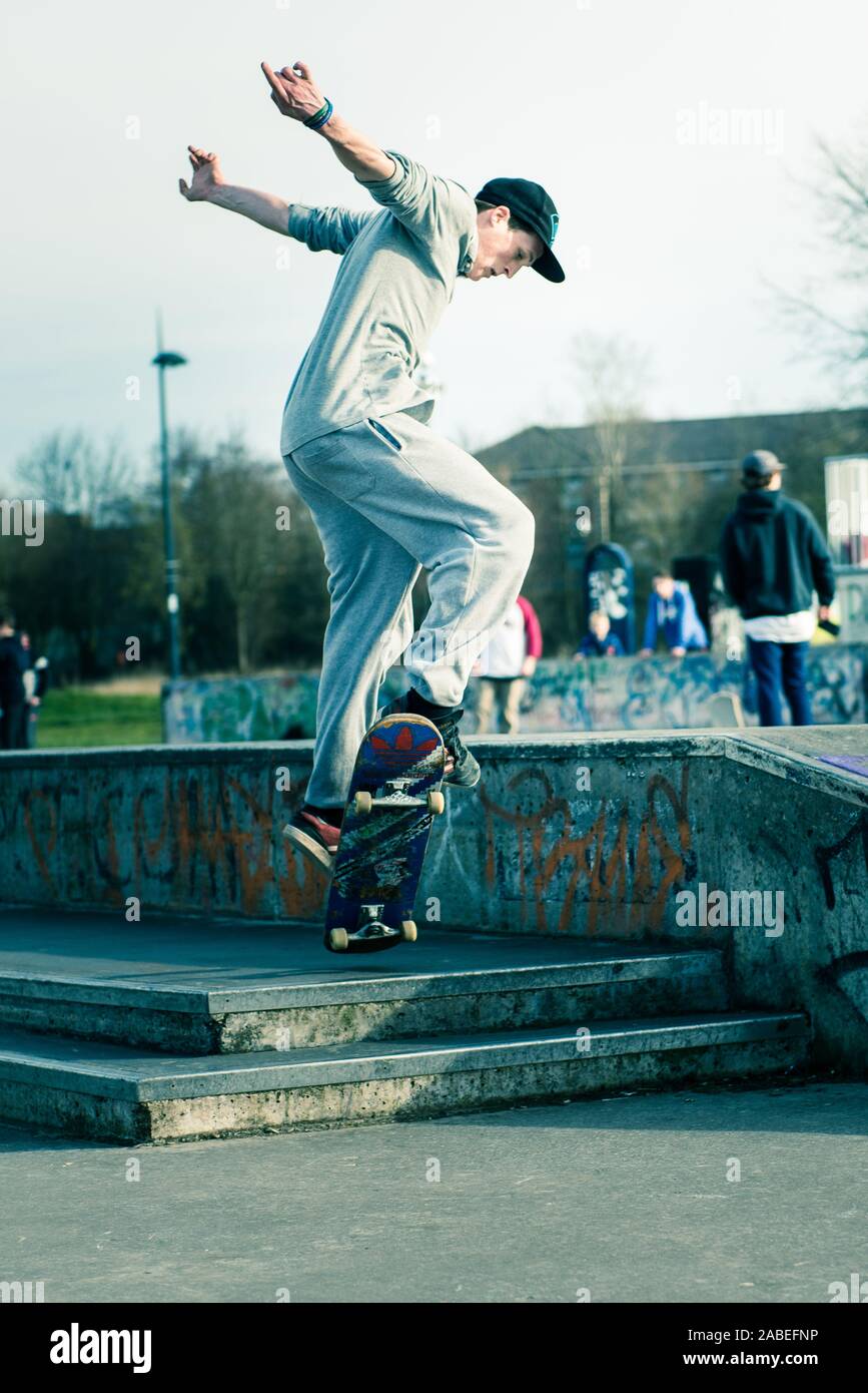 A group of professional skaters, skateboarders practicing ollieing off ...