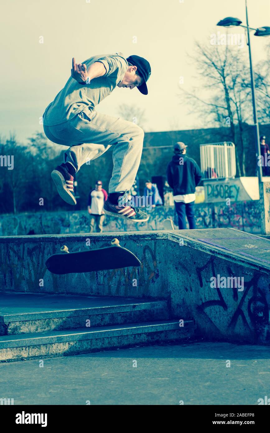 A group of professional skaters, skateboarders practicing ollieing off ...
