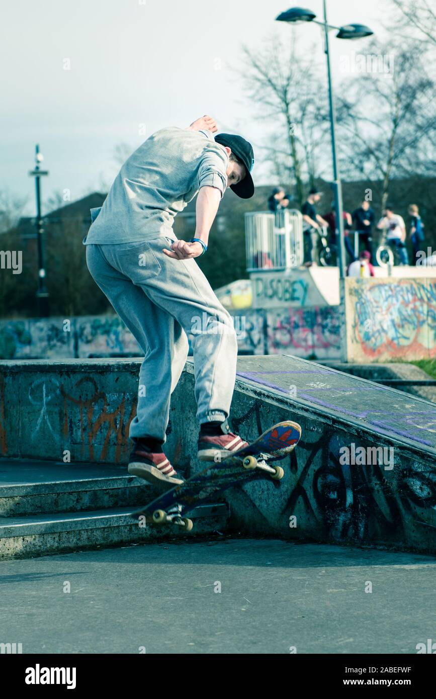 A group of professional skaters, skateboarders practicing ollieing off ...