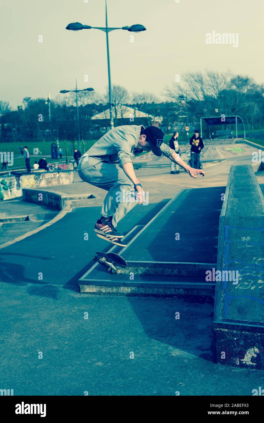 A group of professional skaters, skateboarders practicing ollieing off ...