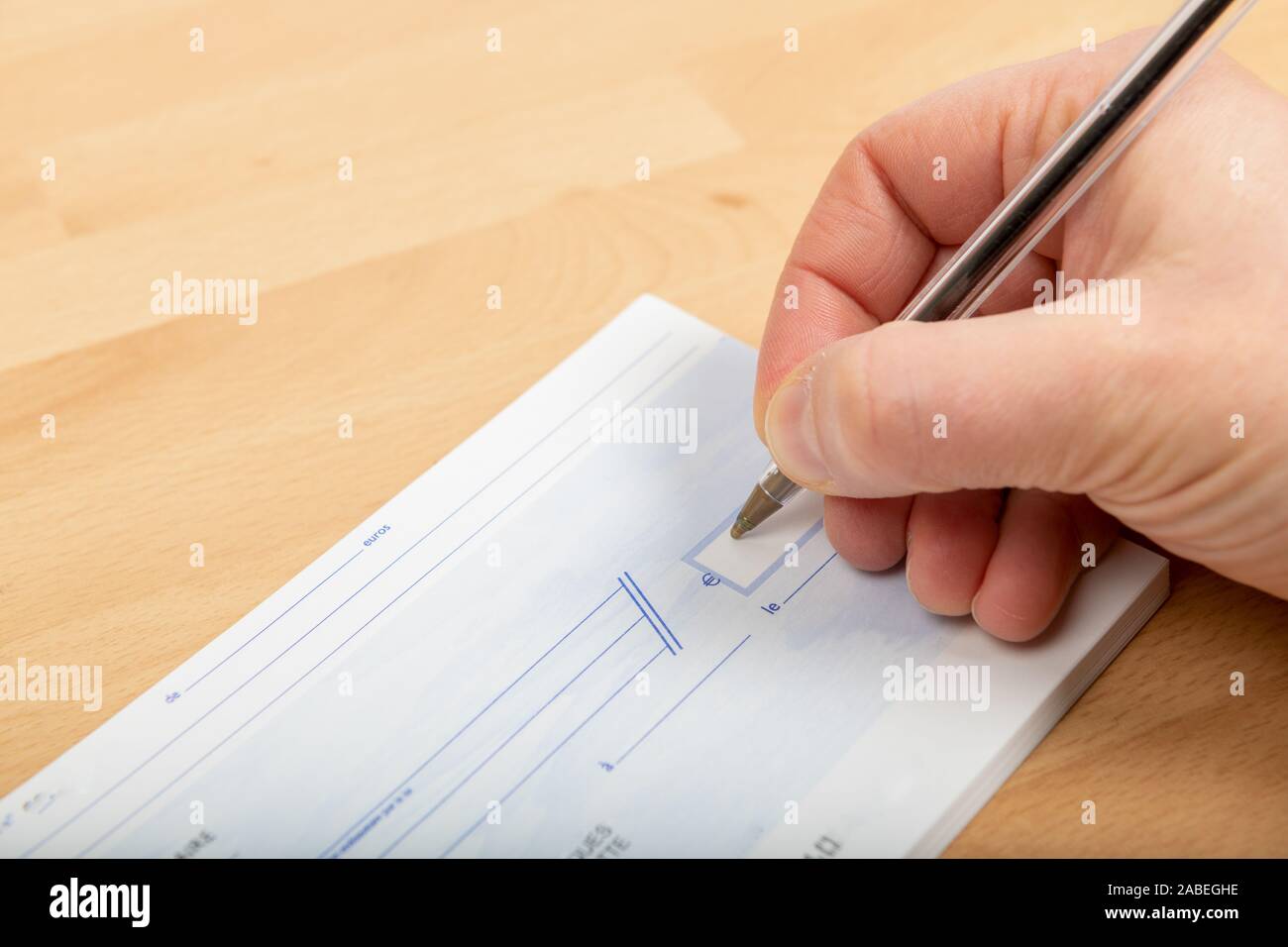 Person filling a bank check Stock Photo - Alamy