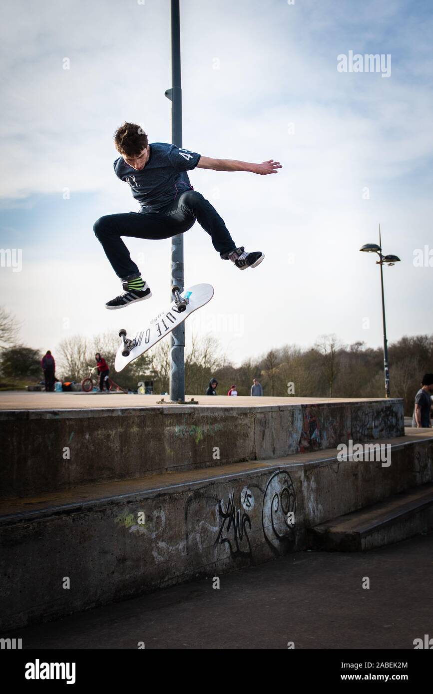 A group of professional skaters, skateboarders practicing ollieing off ...