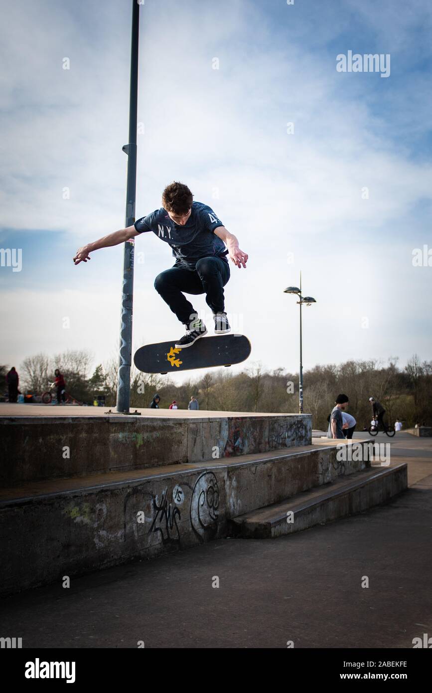 A group of professional skaters, skateboarders practicing ollieing off ...