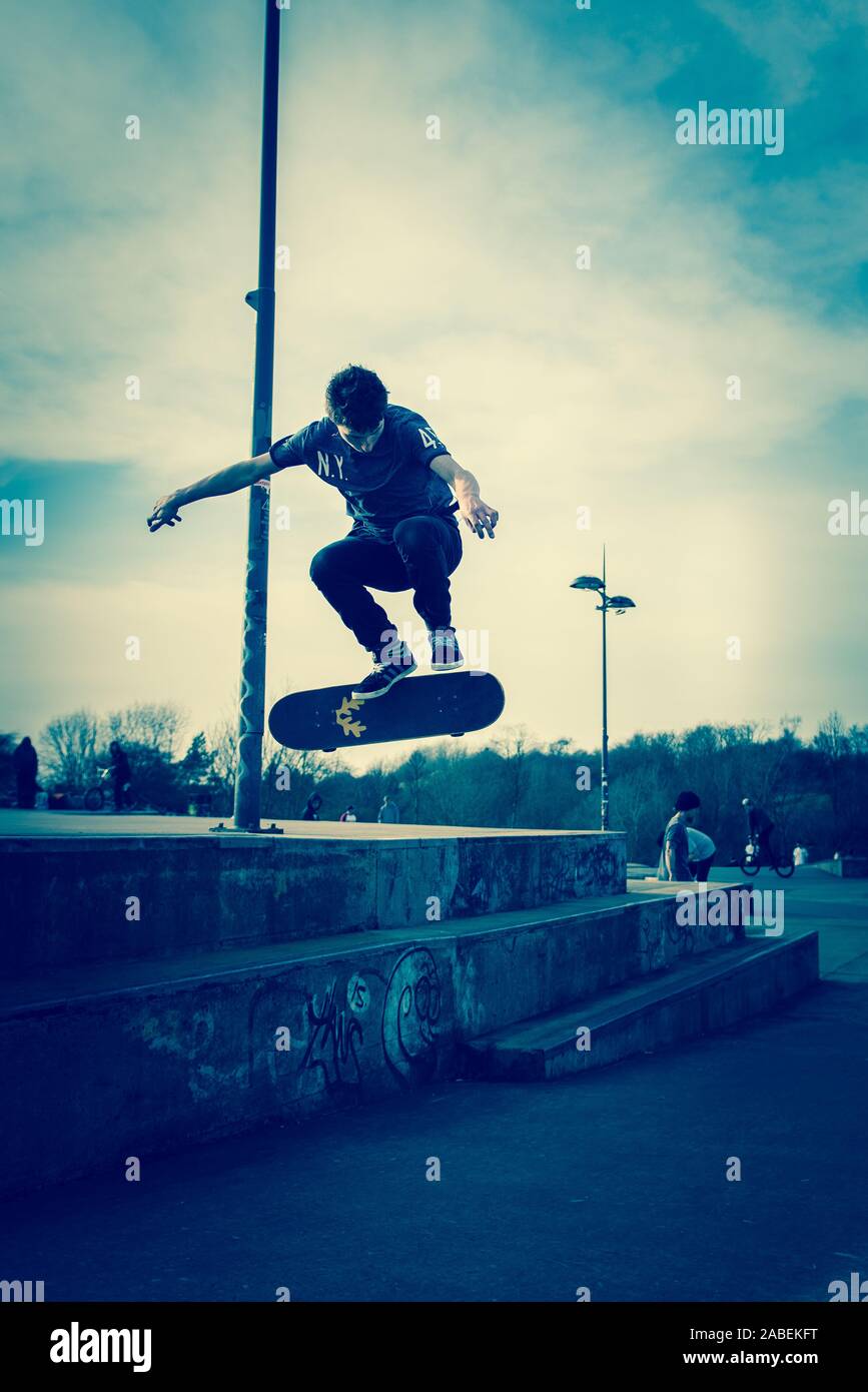 A group of professional skaters, skateboarders practicing ollieing off ...