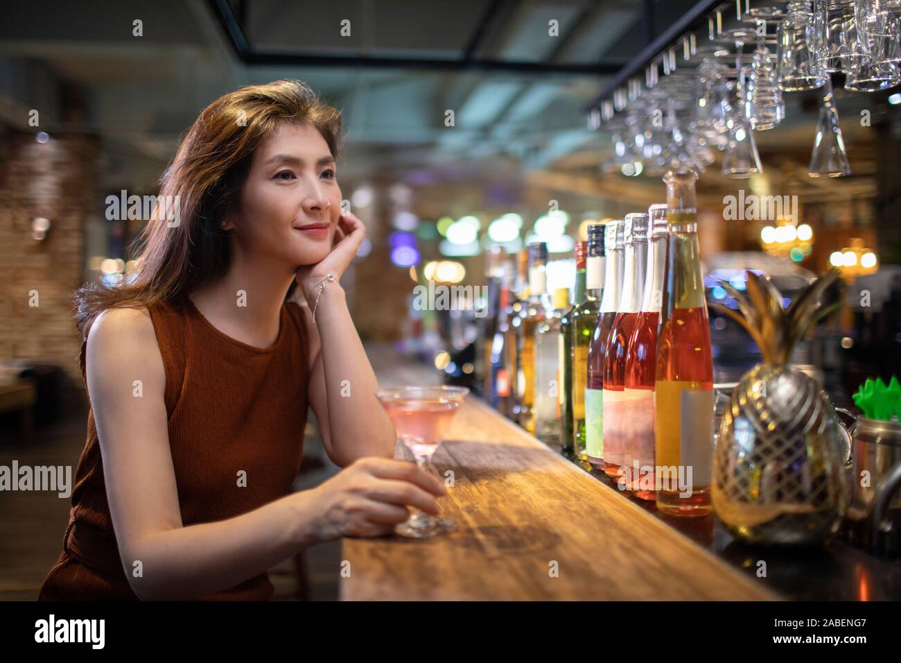 Beautiful woman drinking cocktail in bar Stock Photo - Alamy