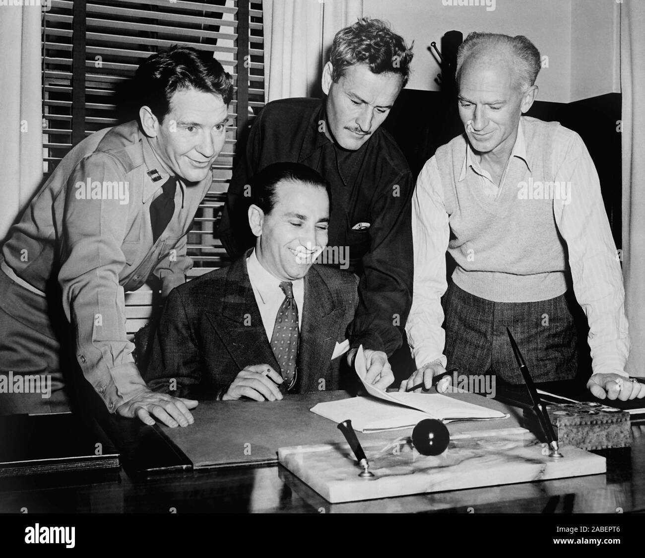 THE STORY OF G.I. JOE, producer Lester Cowan seated in his office with ...