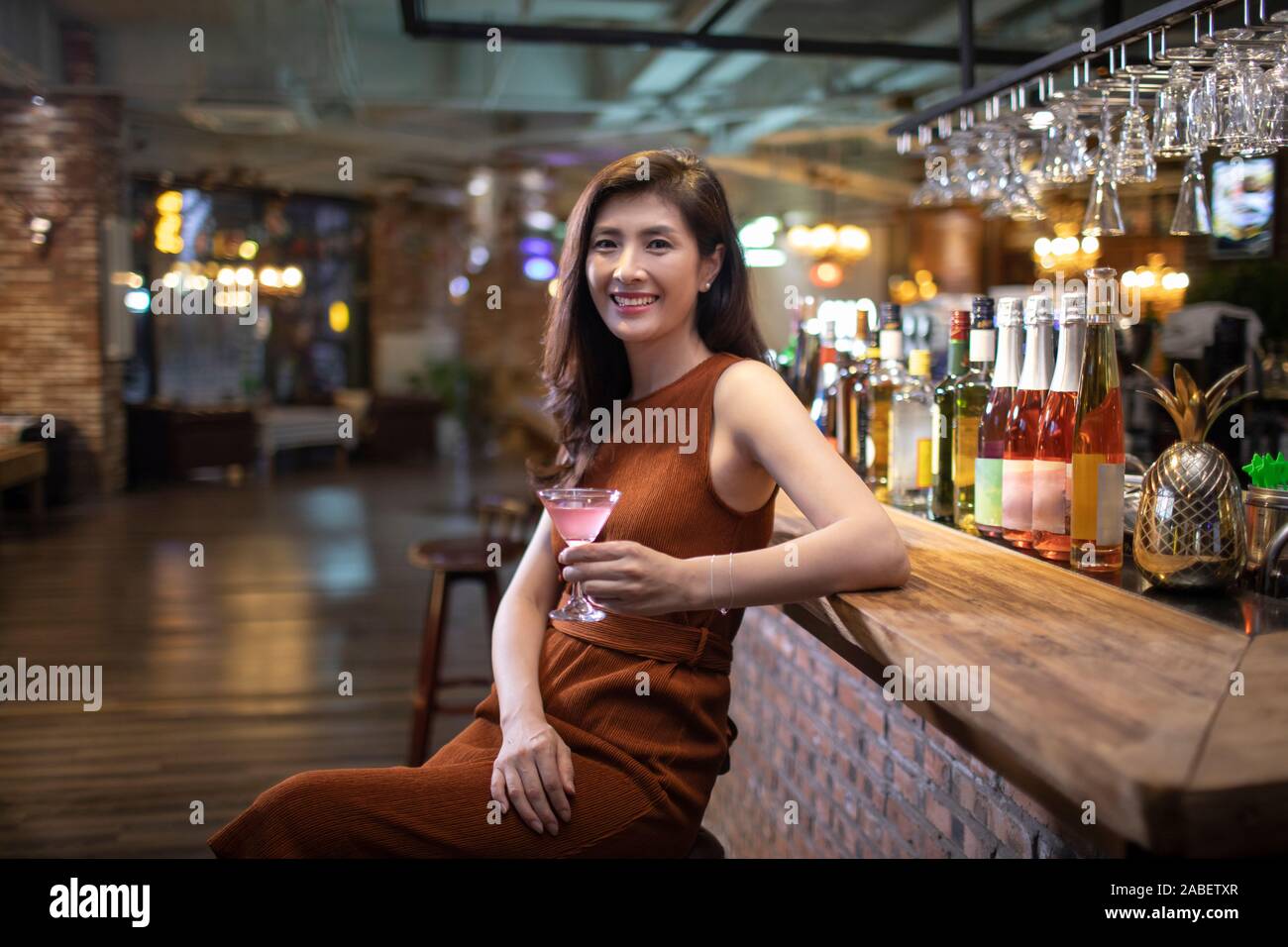 Beautiful woman drinking cocktail in bar Stock Photo - Alamy