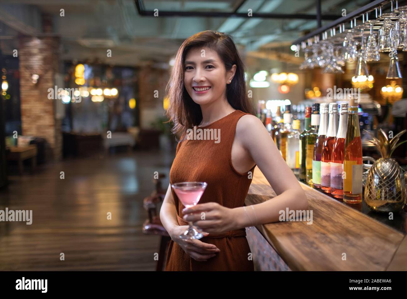 Beautiful woman drinking cocktail in bar Stock Photo - Alamy