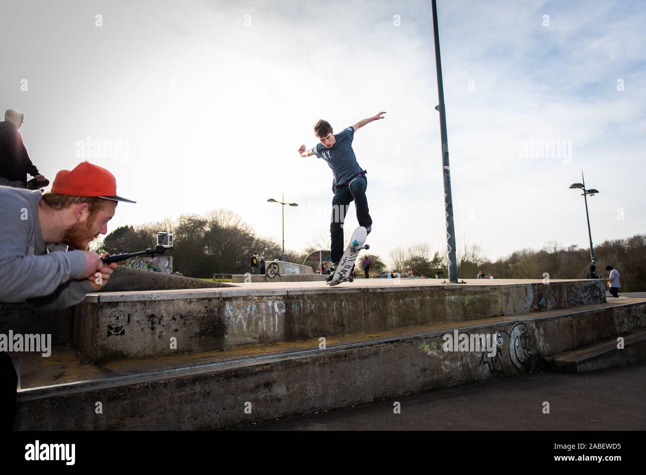 A group of professional skaters, skateboarders practicing ollieing off ...