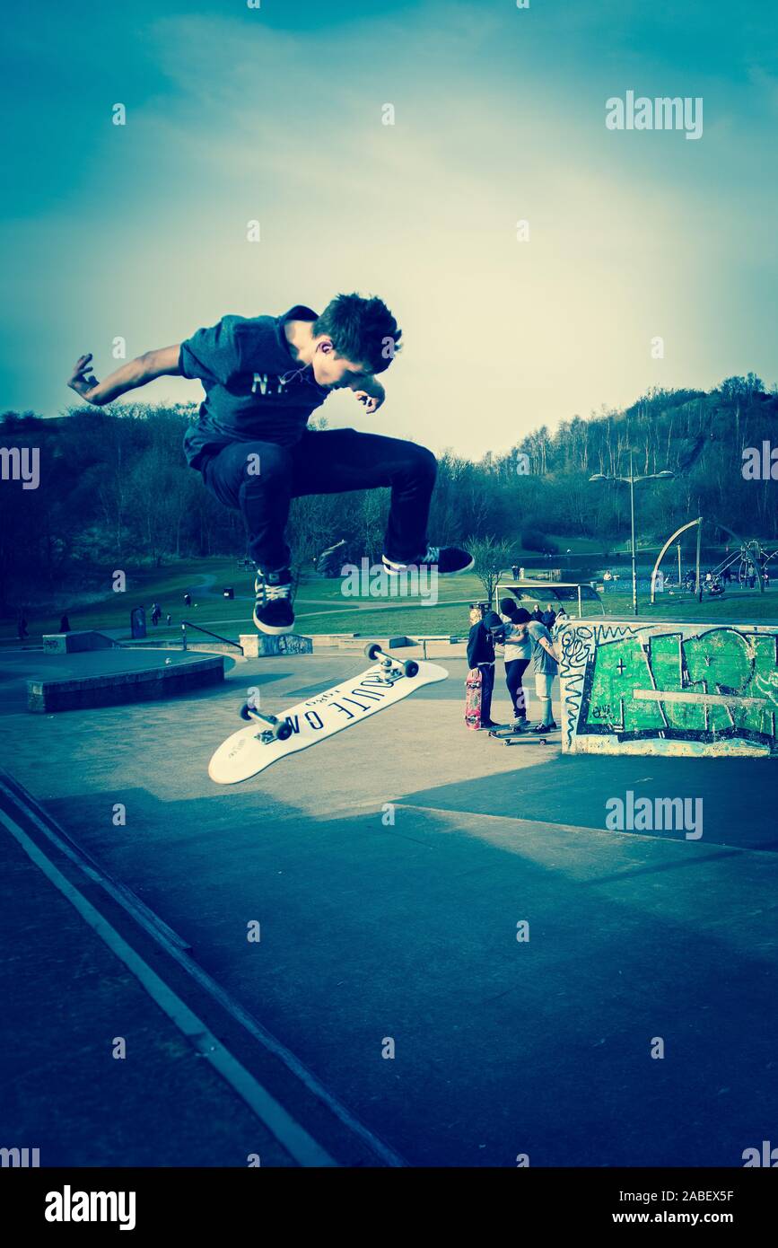 A group of professional skaters, skateboarders practicing ollieing off ...