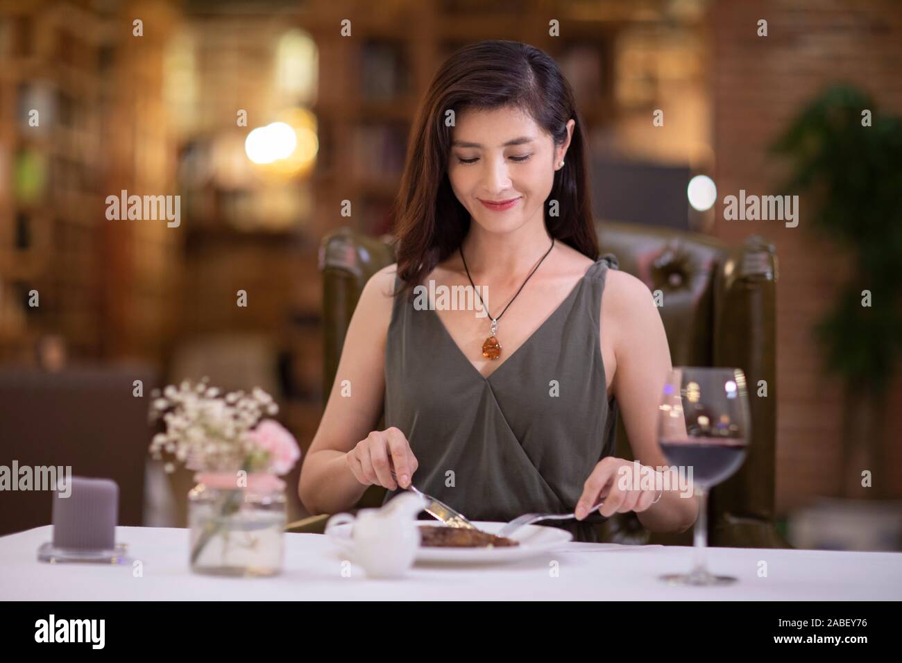 Elegant woman eating steak in western restaurant Stock Photo - Alamy