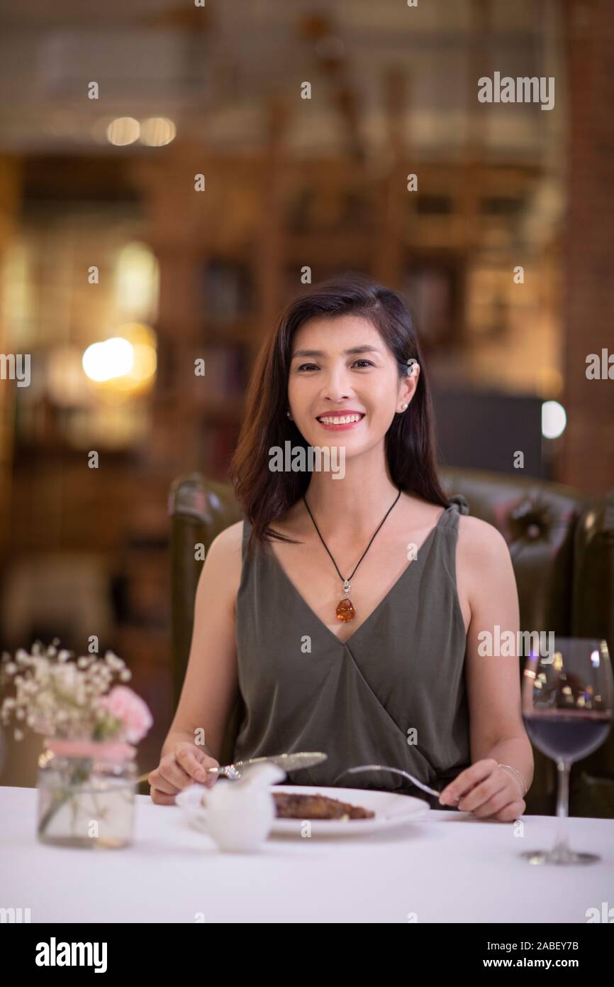 Elegant woman eating steak in western restaurant Stock Photo - Alamy