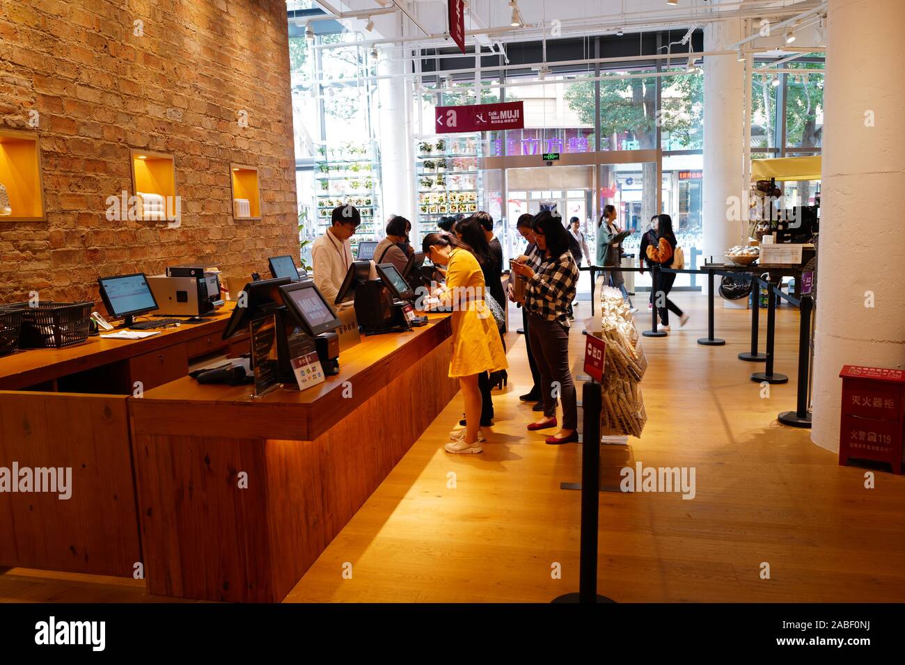 People check out at the newly opened Muji flagship store in Kunming ...