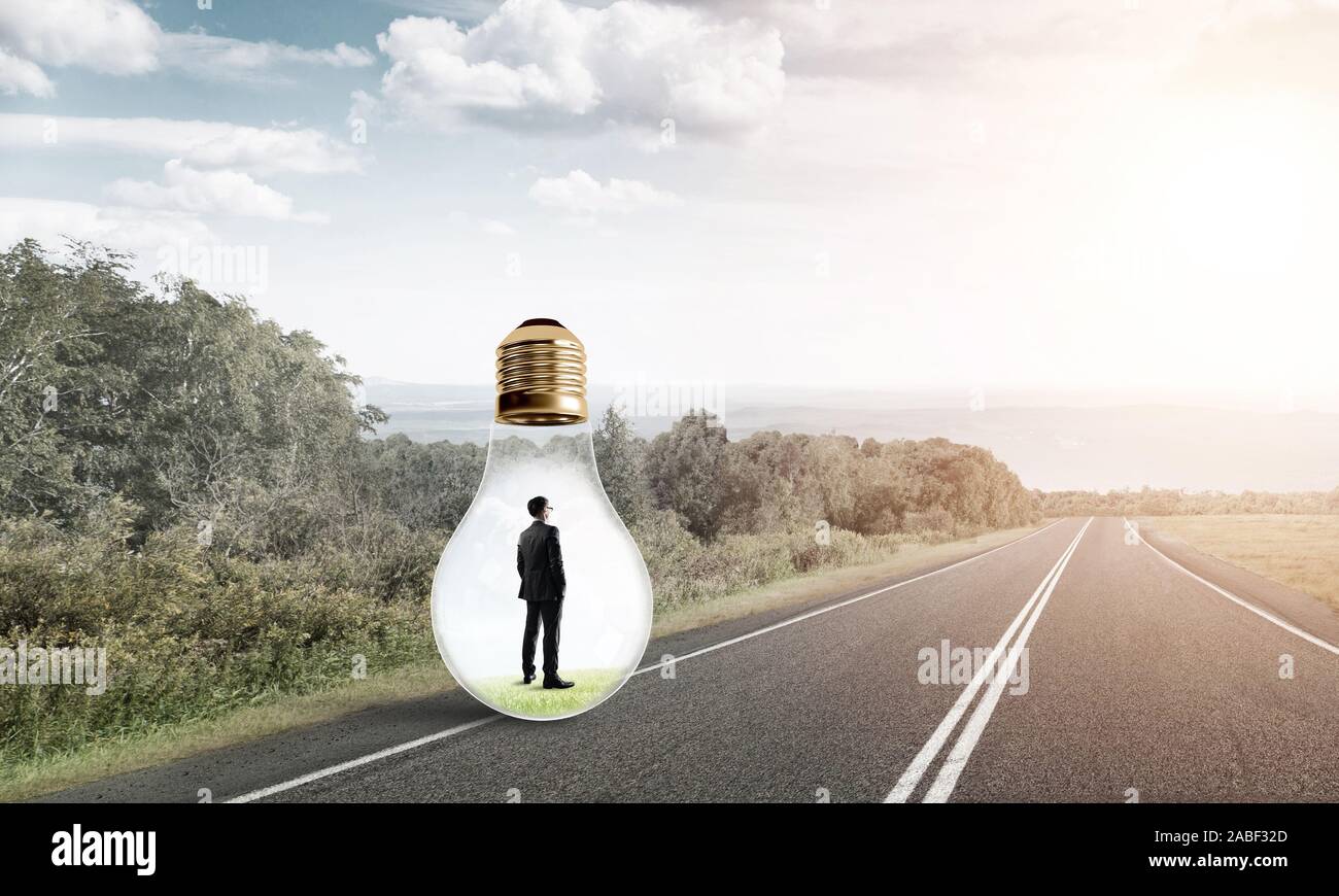 Businessman inside light bulb Stock Photo - Alamy