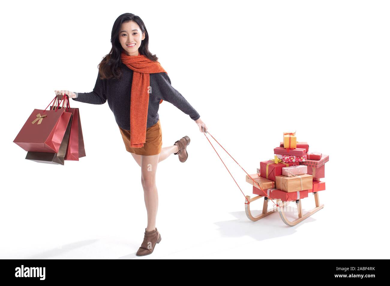 Happy young woman pulling sled Stock Photo - Alamy