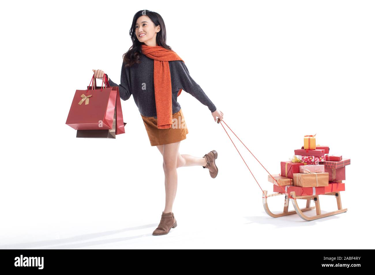 Happy young woman pulling sled Stock Photo - Alamy