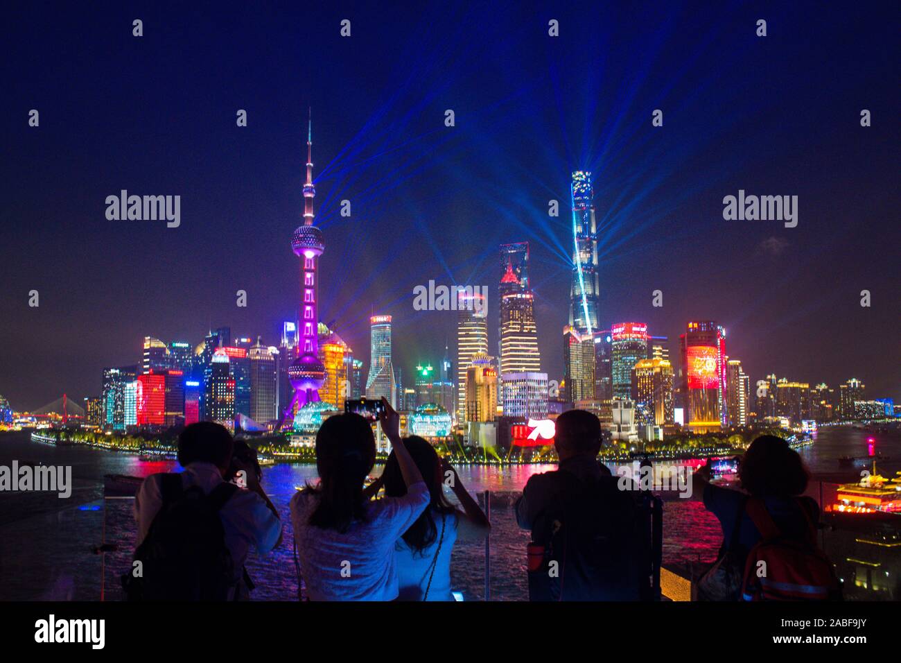 Tourists gather at the Bund to enjoy the light show performed with ...