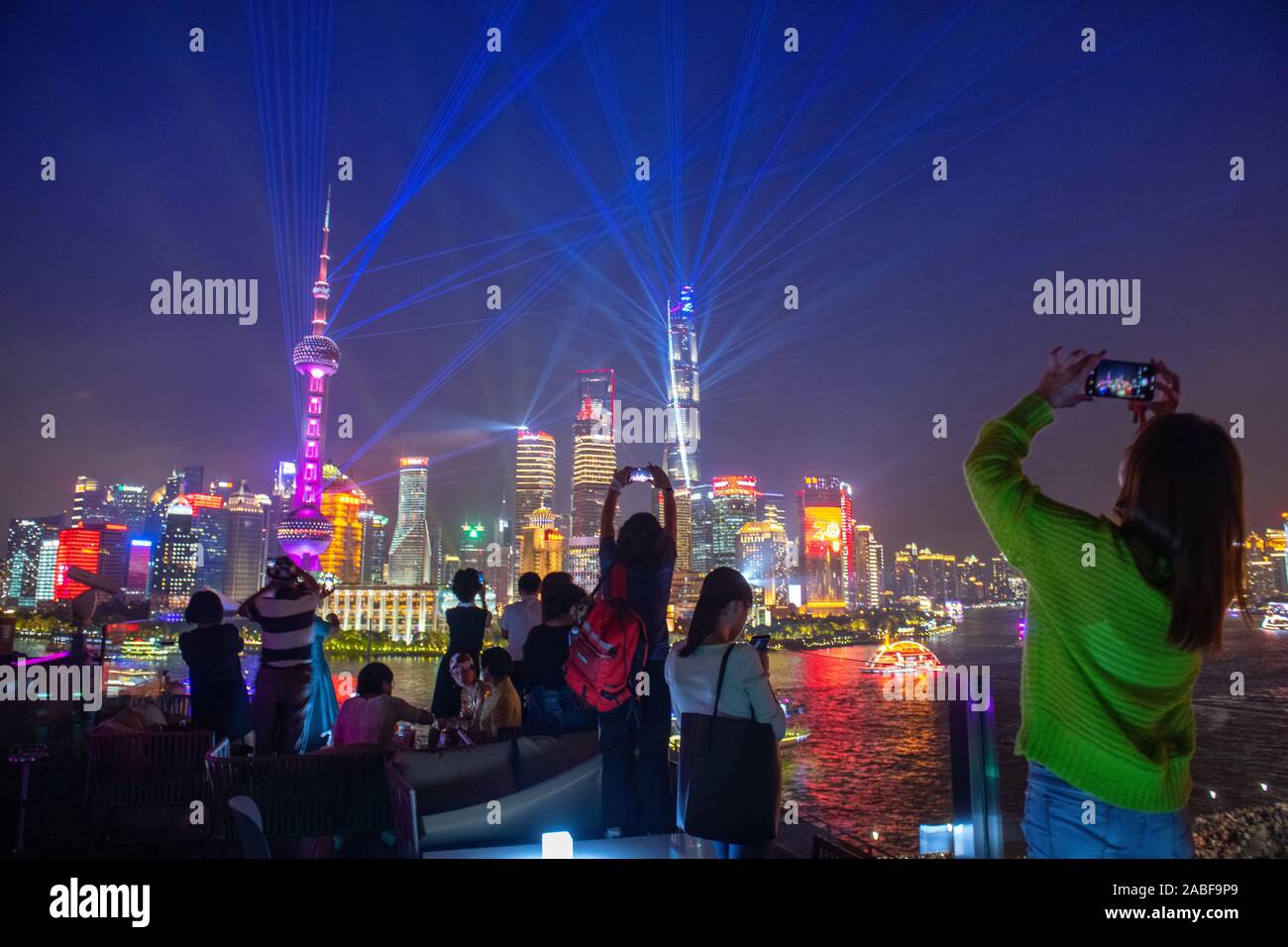 Tourists gather at the Bund to enjoy the light show performed with ...