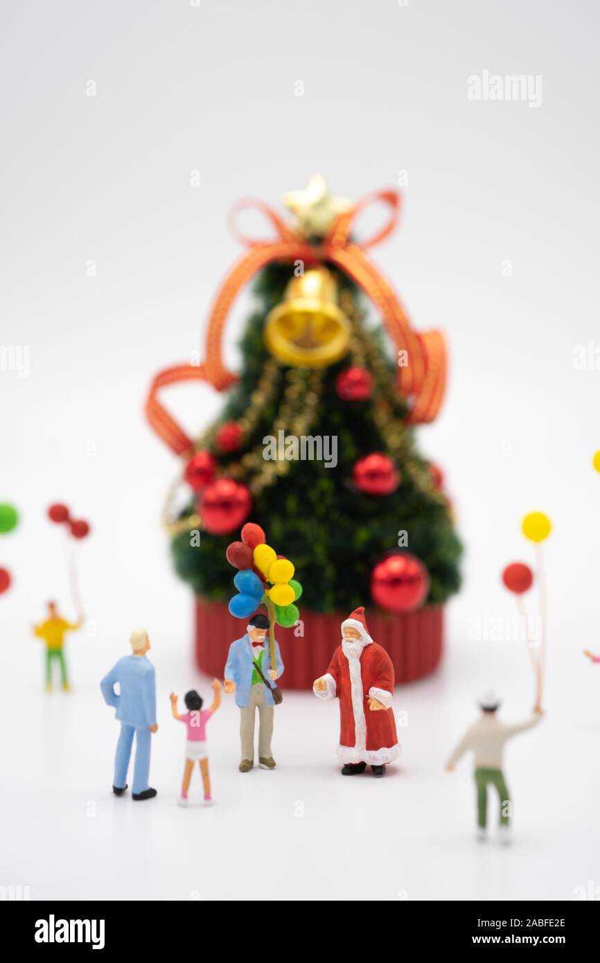 Family Miniature people standing on Christmas tree Celebrate Christmas ...
