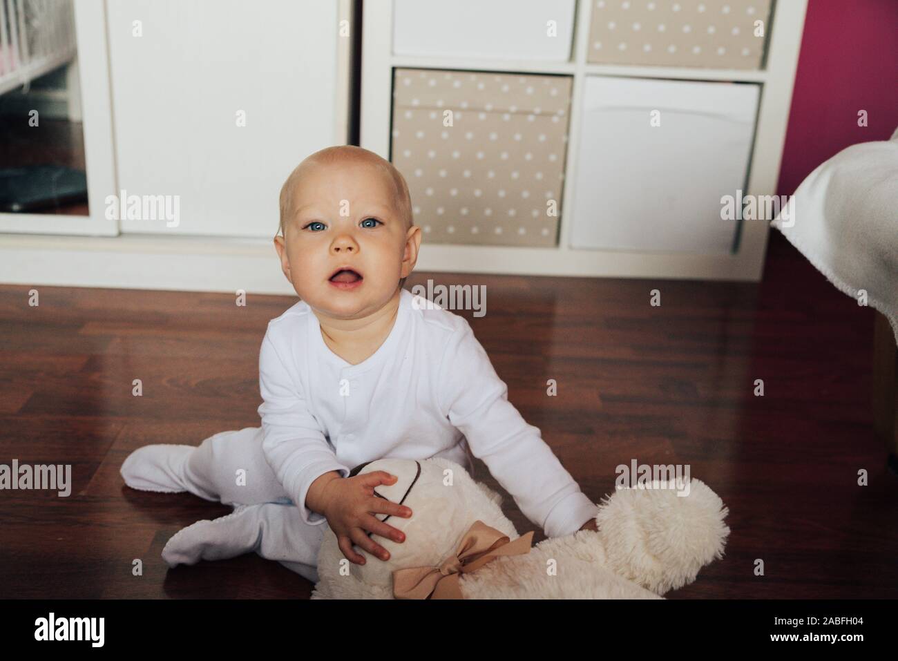 baby girl with teddy bear on the floor Stock Photo - Alamy