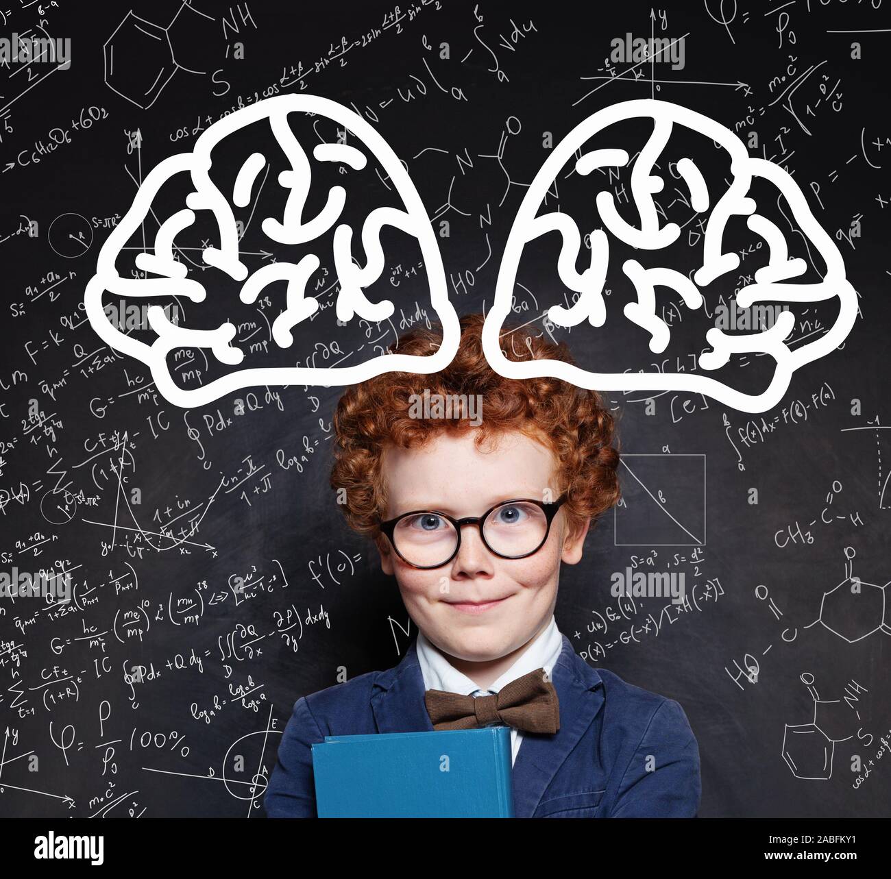 Young boy genius and brain power. Happy redhead kid against chalkboard ...