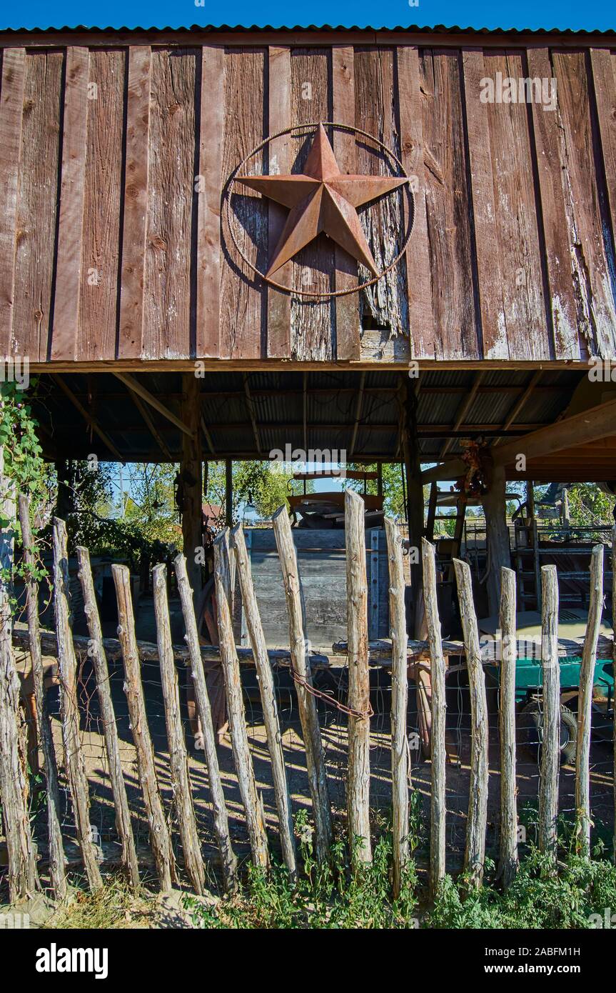 The rusty metal star of Texas hung on the outside wooden walls of an ...