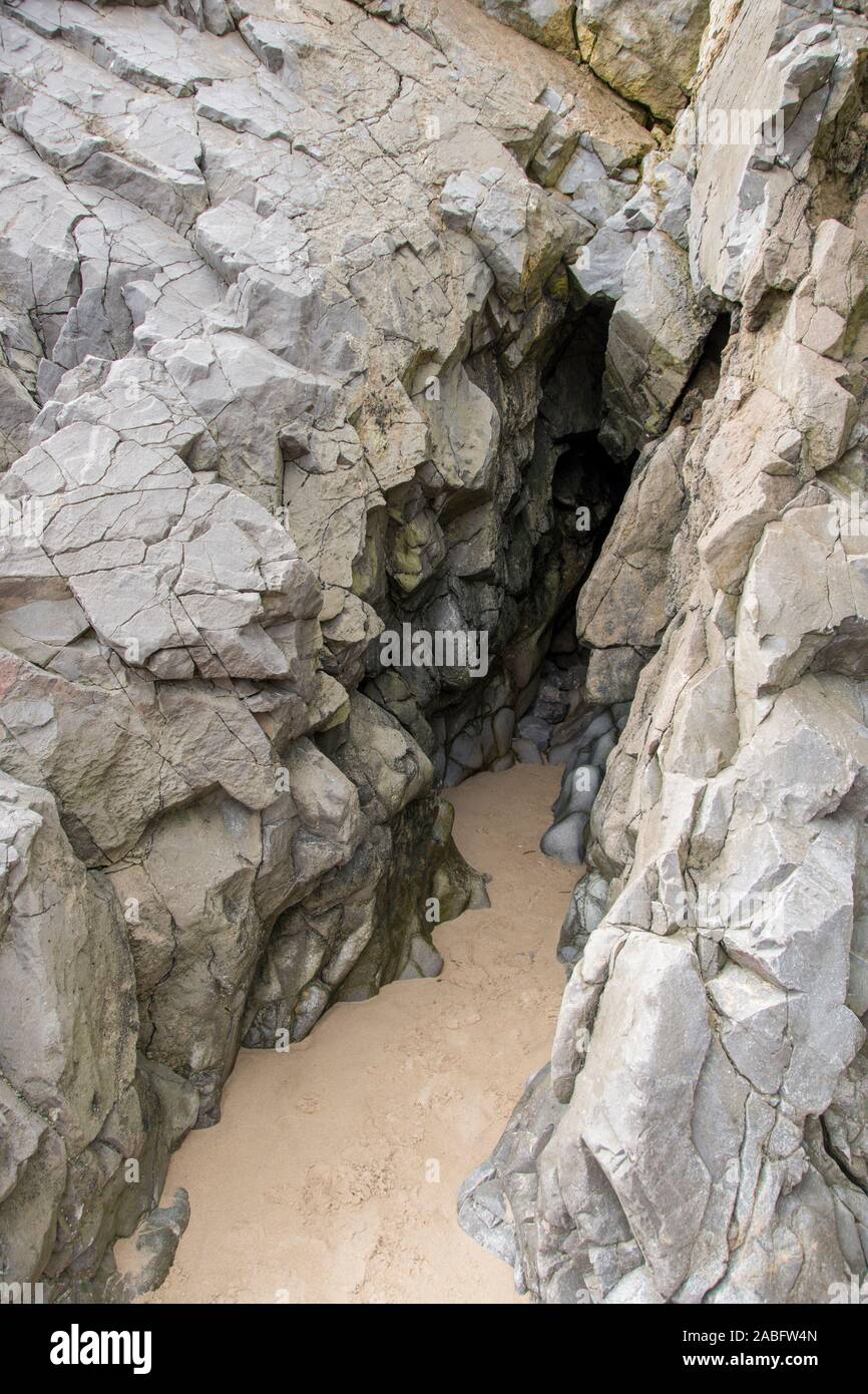 A close look at a craggy little cave opening in the cliff face at Three ...