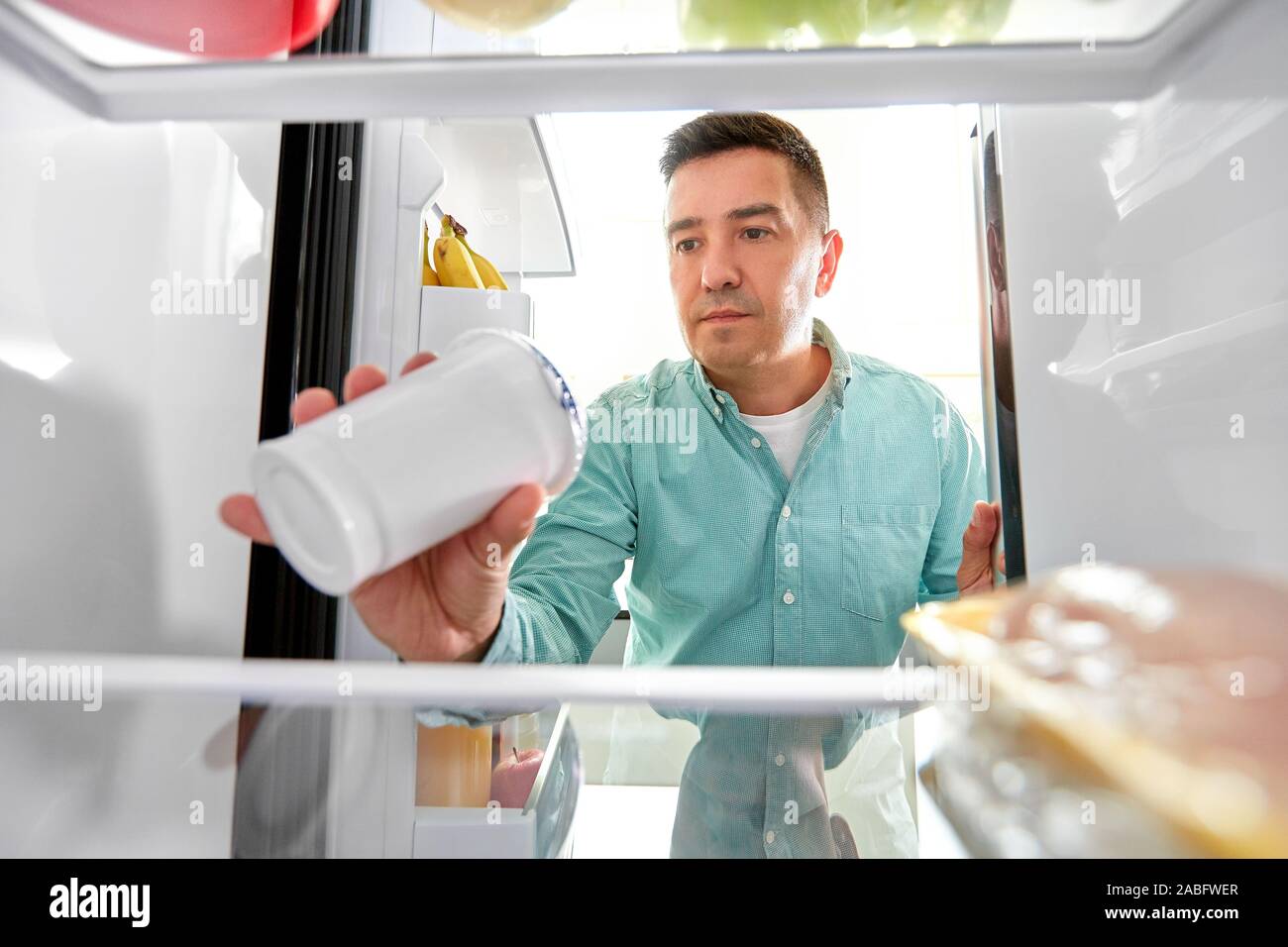 man taking food from fridge at kitchen Stock Photo - Alamy