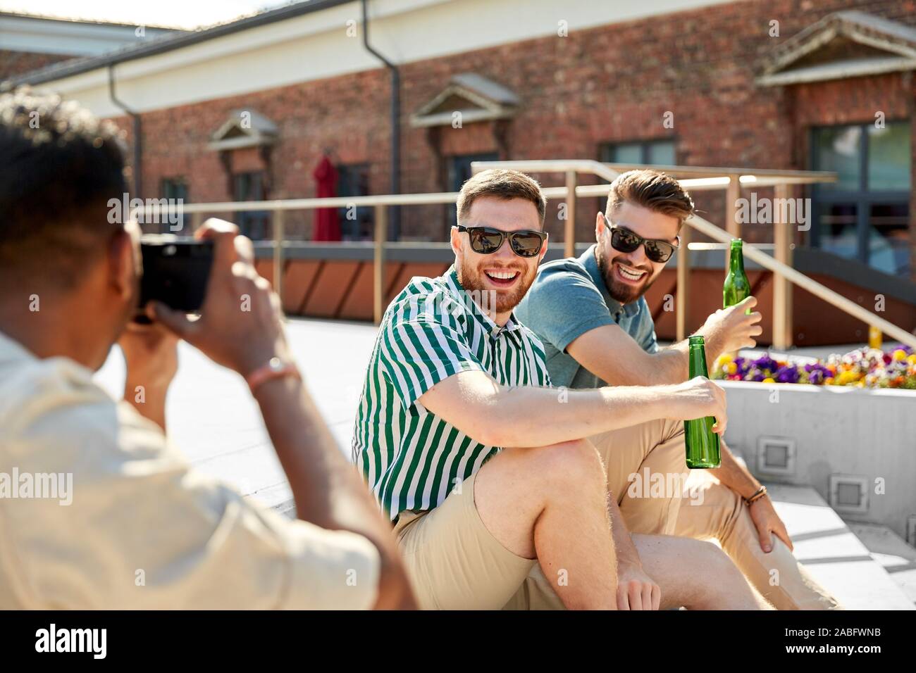 man photographing friends drinking beer on street Stock Photo - Alamy