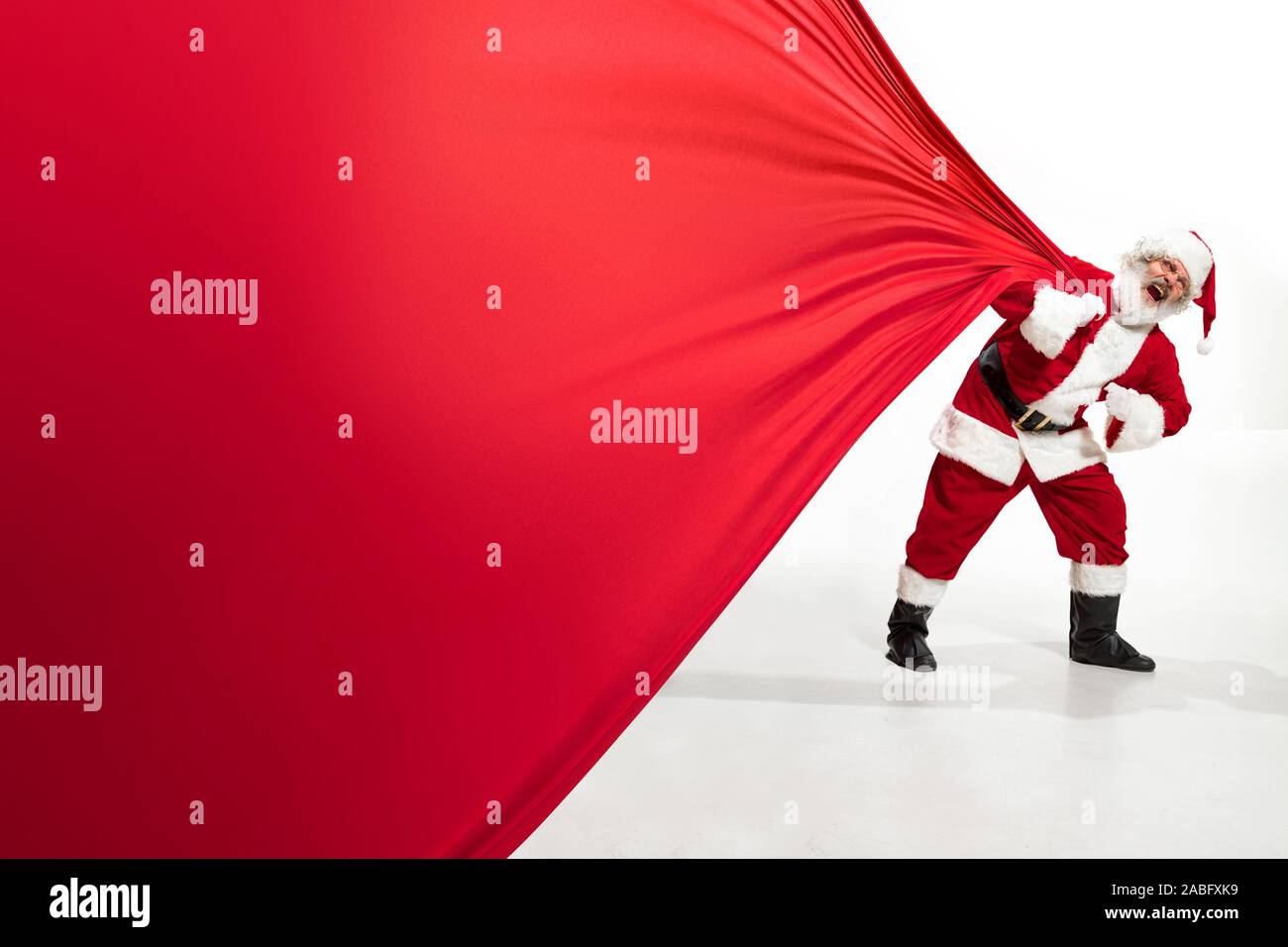 Santa Claus pulling huge bag full of christmas presents isolated on ...