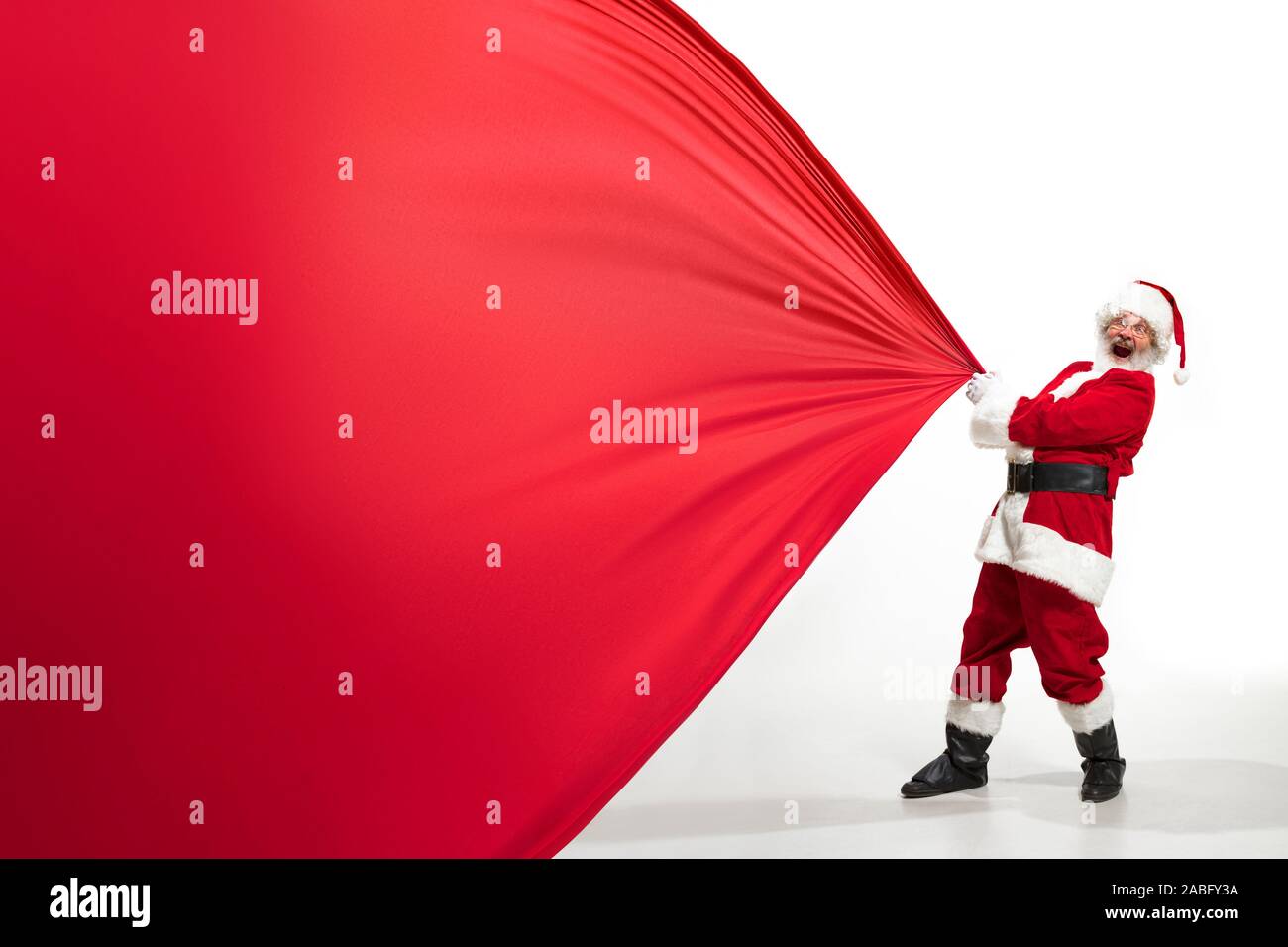 Santa Claus pulling huge bag full of christmas presents isolated on ...